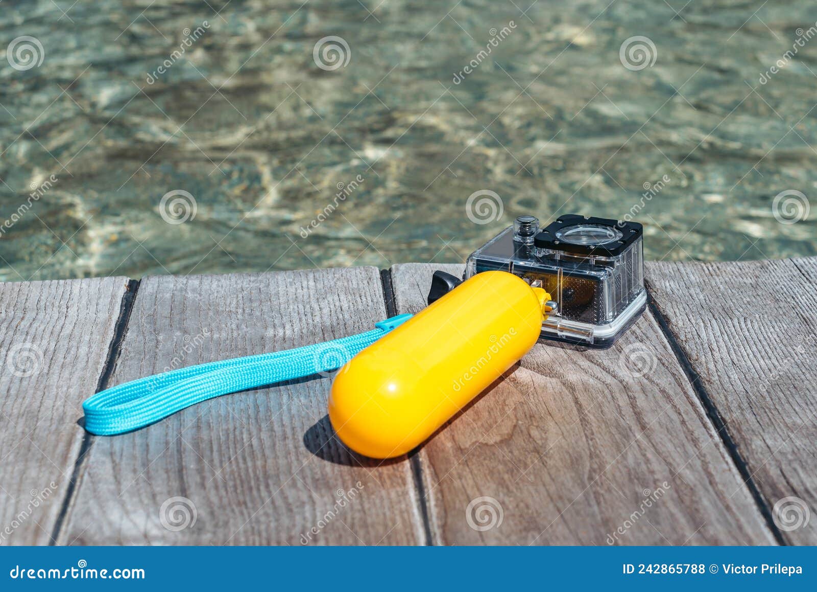 An Action Camera with a Yellow Float Lies on a Wooden Deck Against the ...