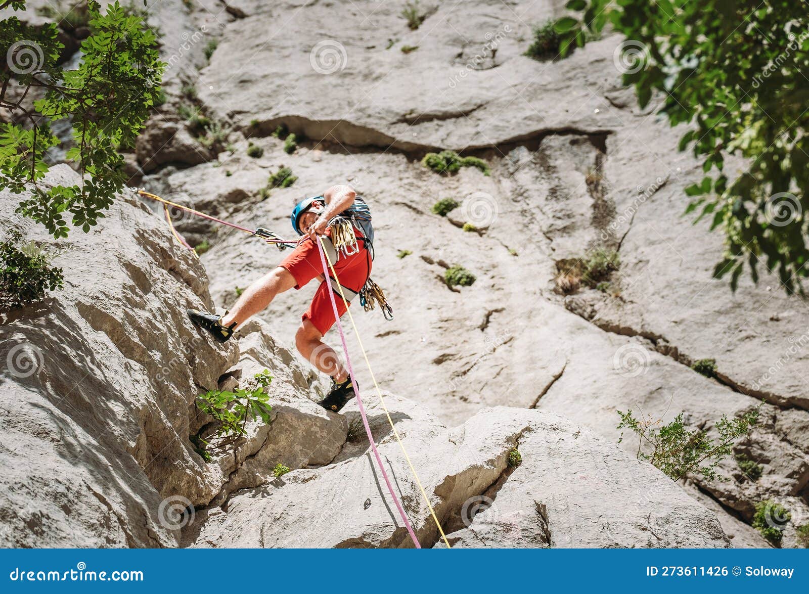 Active Climber Middle Age Man in Protective Helmet while Abseiling from ...