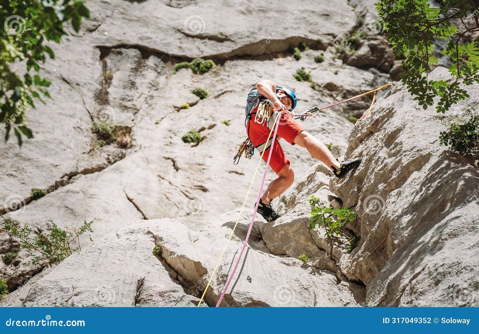 Active Climber Middle Age Man in Protective Helmet while Abseiling from ...