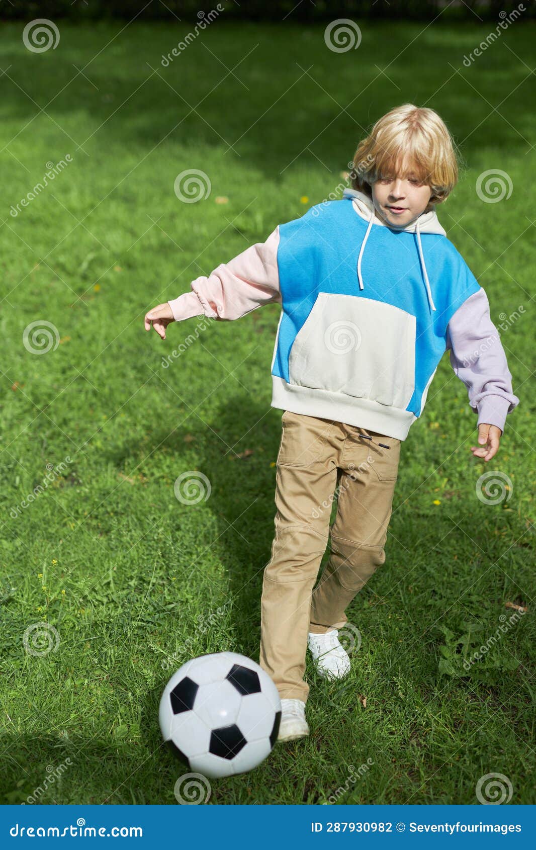 Active Tween Boy Playing Football on Green Grass in Sunlight Stock ...