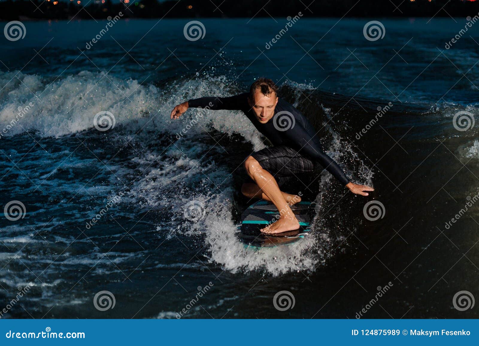 Active Wakesurfer Jumping on a Wake Board Against the Blue River Stock ...