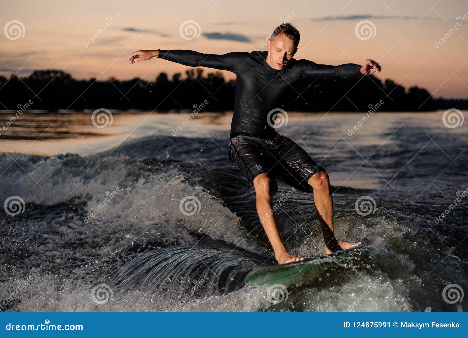 Active Wakesurfer in Black Swimsuit Jumping on a Wake Board at the ...