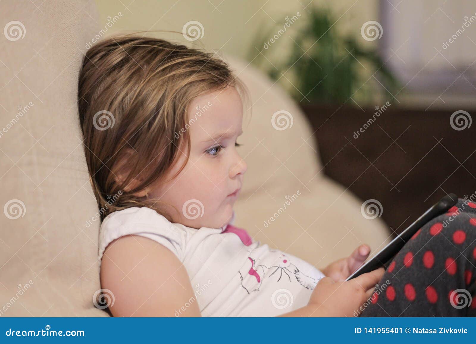 Addicted child using phone stock image. Image of indoors - 141955401