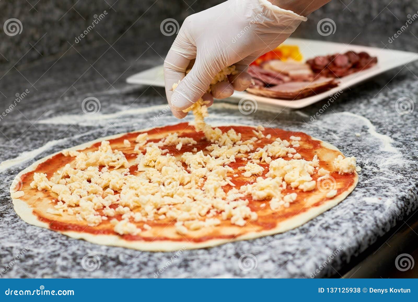 Adding cheese to pizza. stock photo. Image of cooking - 137125938