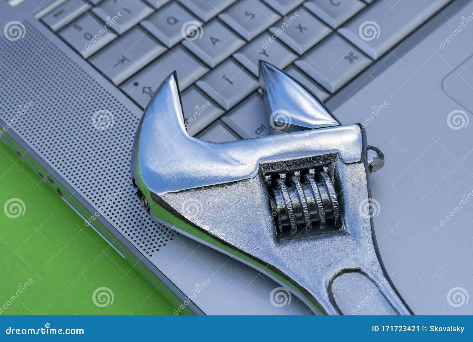 Adjustable Wrench Next To a Silver Laptop. Computer Service ...