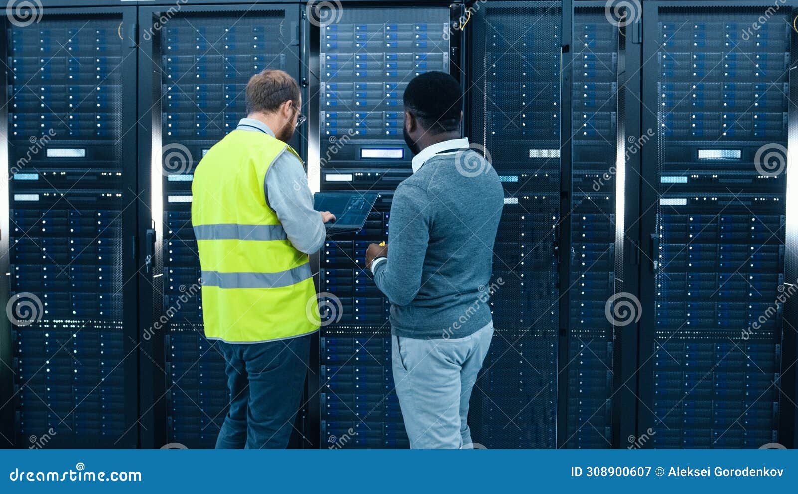 It Administrator with a Laptop Computer in High Visibility Vest and ...
