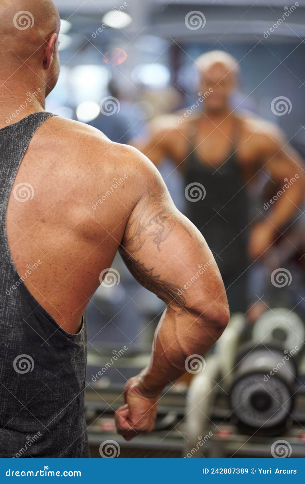 Admiring His Physique. a Muscular Bodybuilder Flexing His Muscles while ...