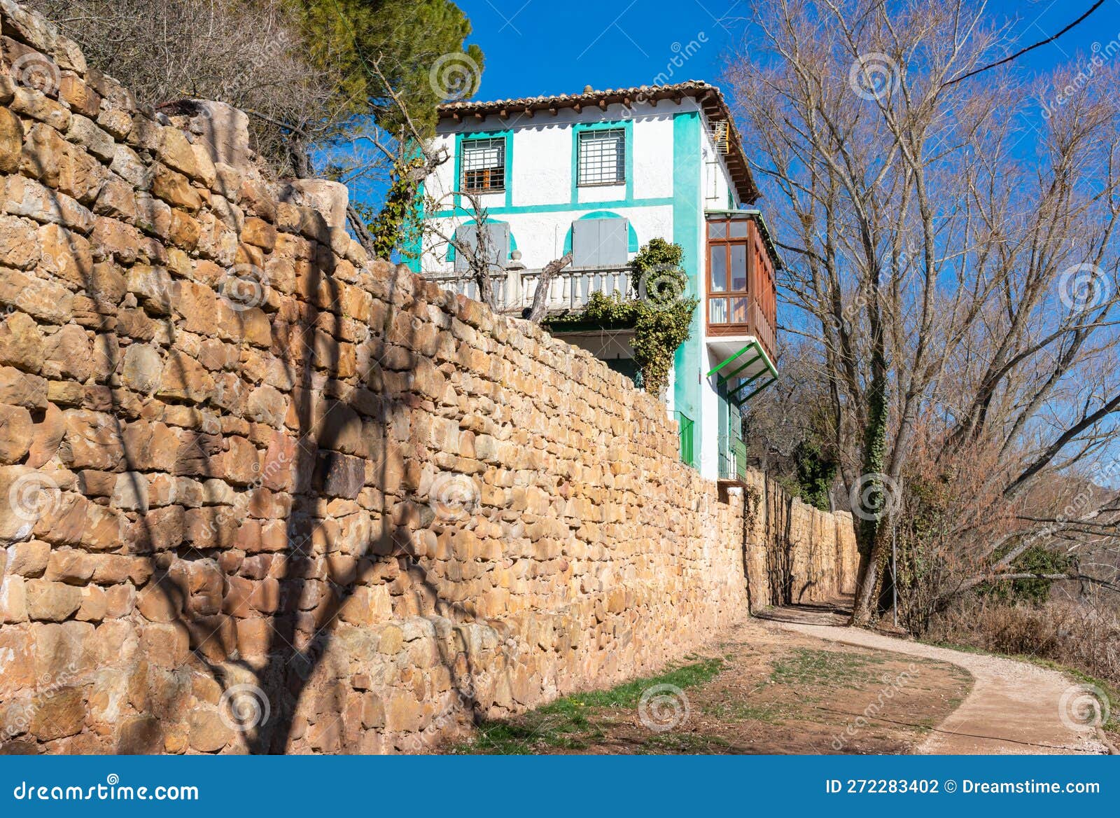 Adobe and Stone Wall with Picturesque House Stock Photo - Image of ...