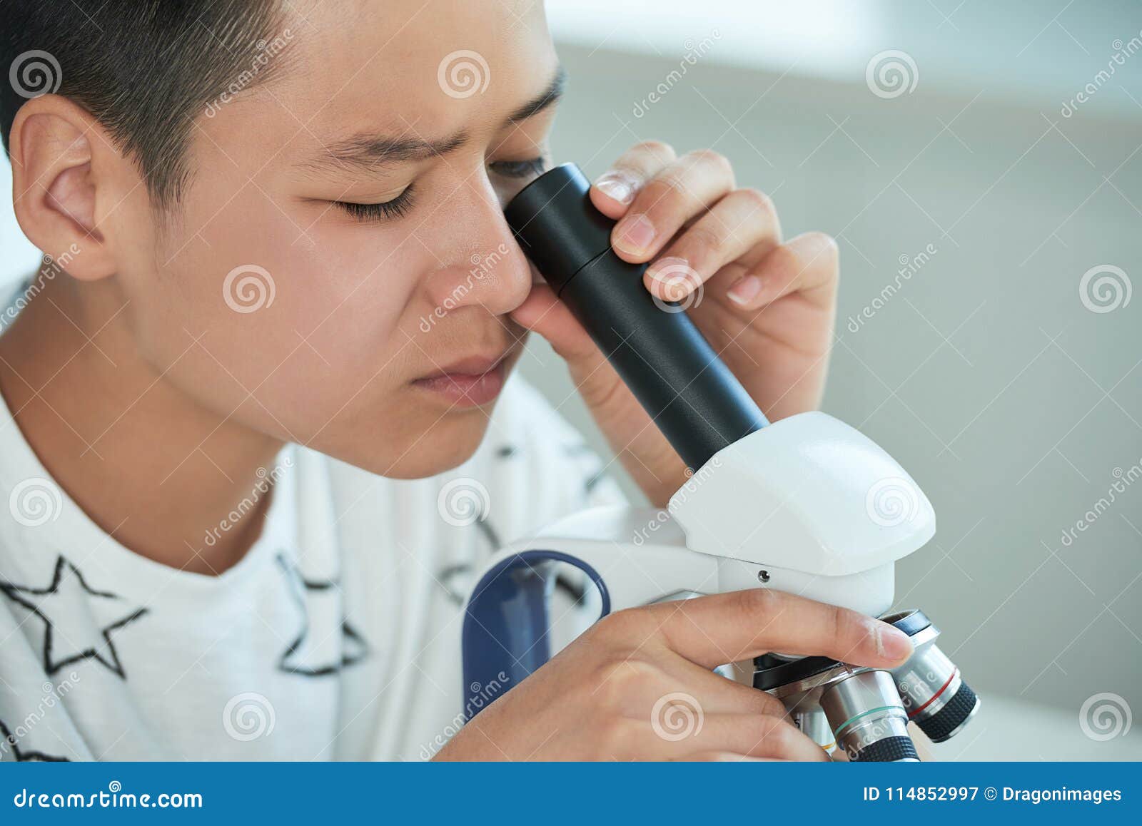 Adolescente Curioso Que Usa El Microscopio Imagen de archivo - Imagen ...