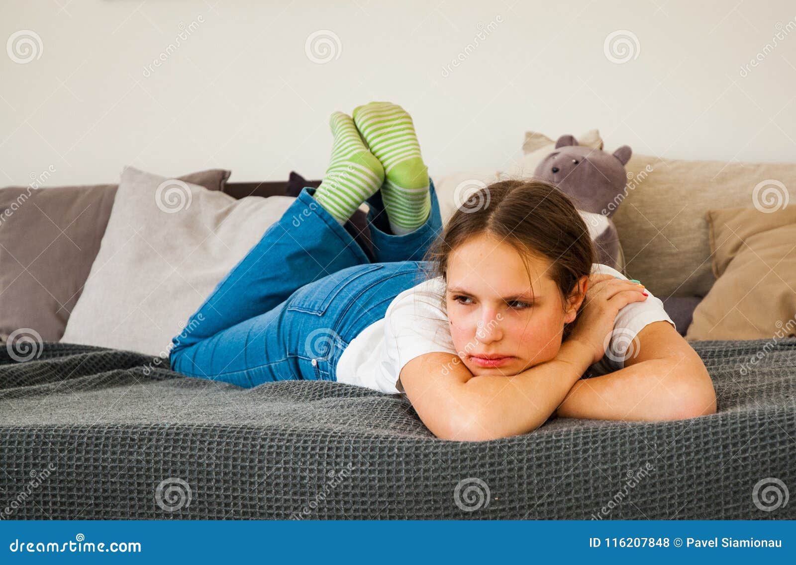 Adolescente En Los Vaqueros Que Ponen En Su Cama Foto de archivo ...