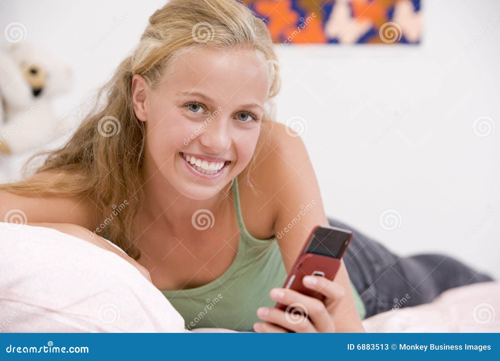 Adolescente Que Miente En Su Cama Usando El Teléfono Móvil Imagen De