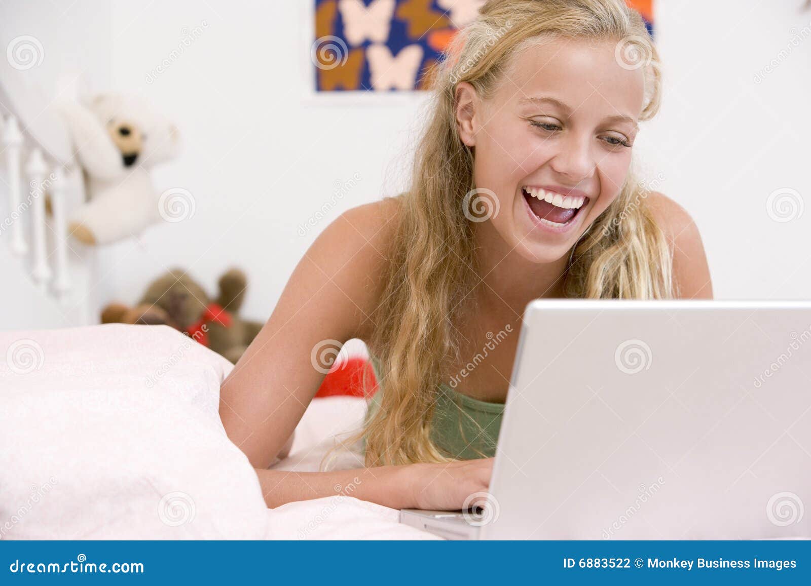 Adolescente Que Miente En Su Cama Usando La Computadora Portátil Foto