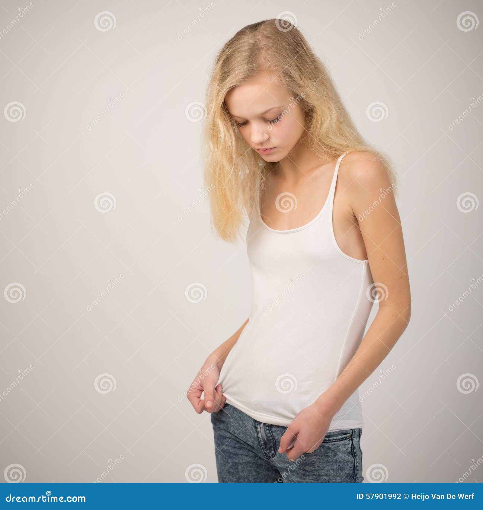 Adolescente Rubio Hermoso En Top Y Vaqueros Del Blanco Foto de archivo ...