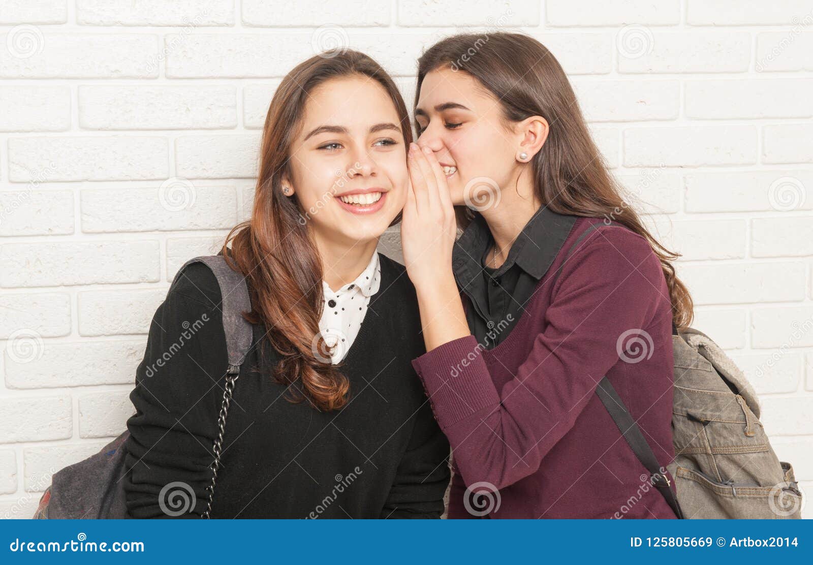 Adolescentes De Las Muchachas Contra Una Pared De Ladrillo Blanca