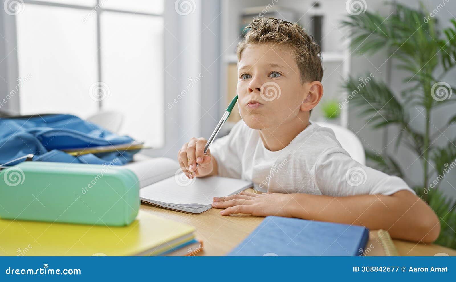 Adorable Blond Boy Student, Focused on Learning, Taking Notes Sitting ...