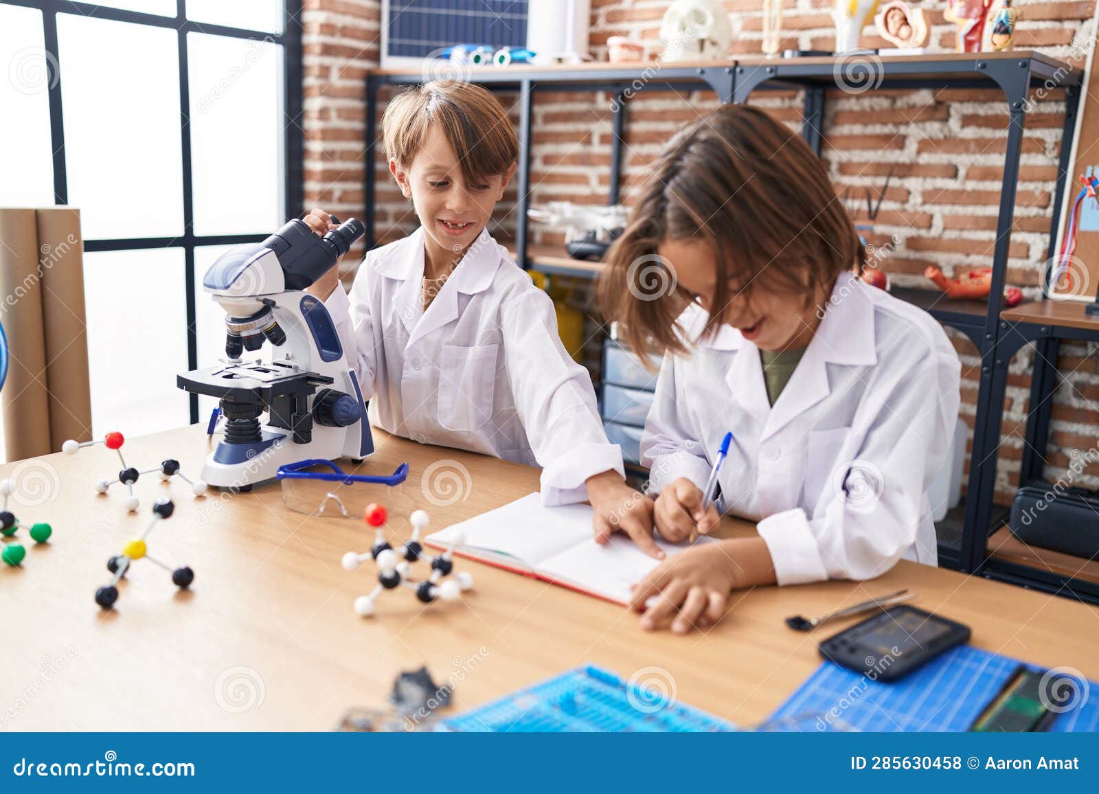 Adorable Boys Students Using Microscope Writing Notes at Laboratory ...