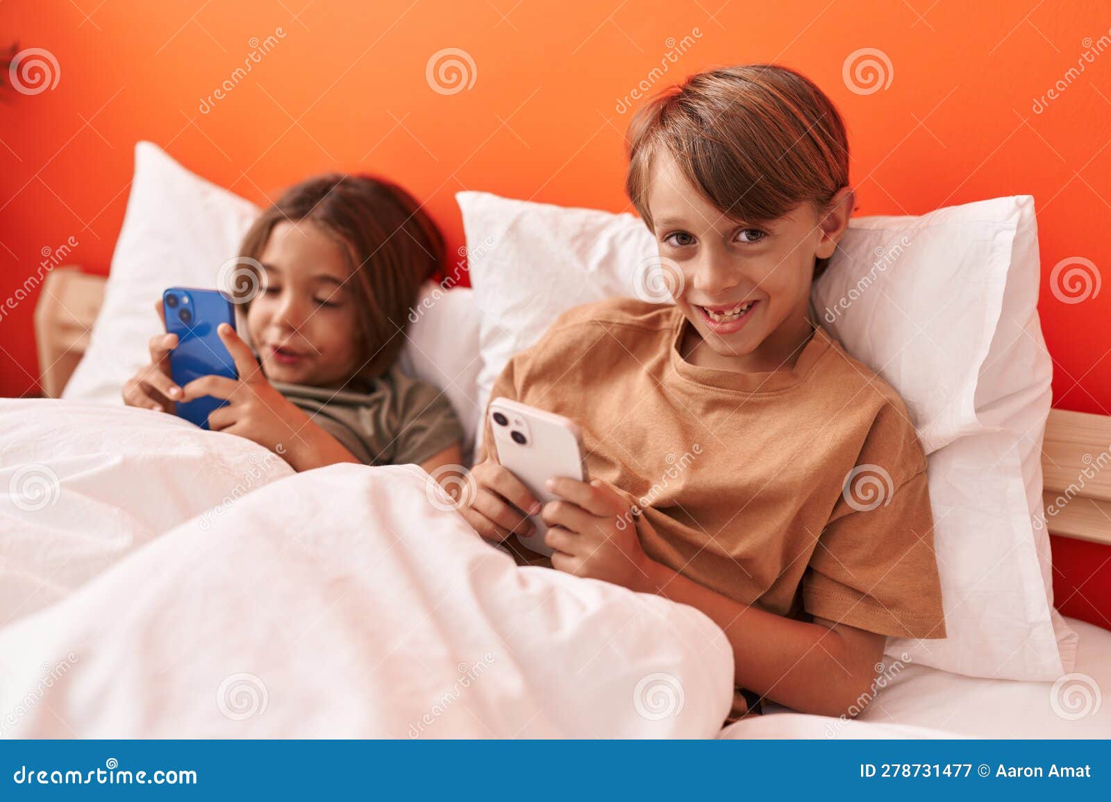 Adorable Boys Using Smartphone Sitting on Bed at Bedroom Stock Image ...