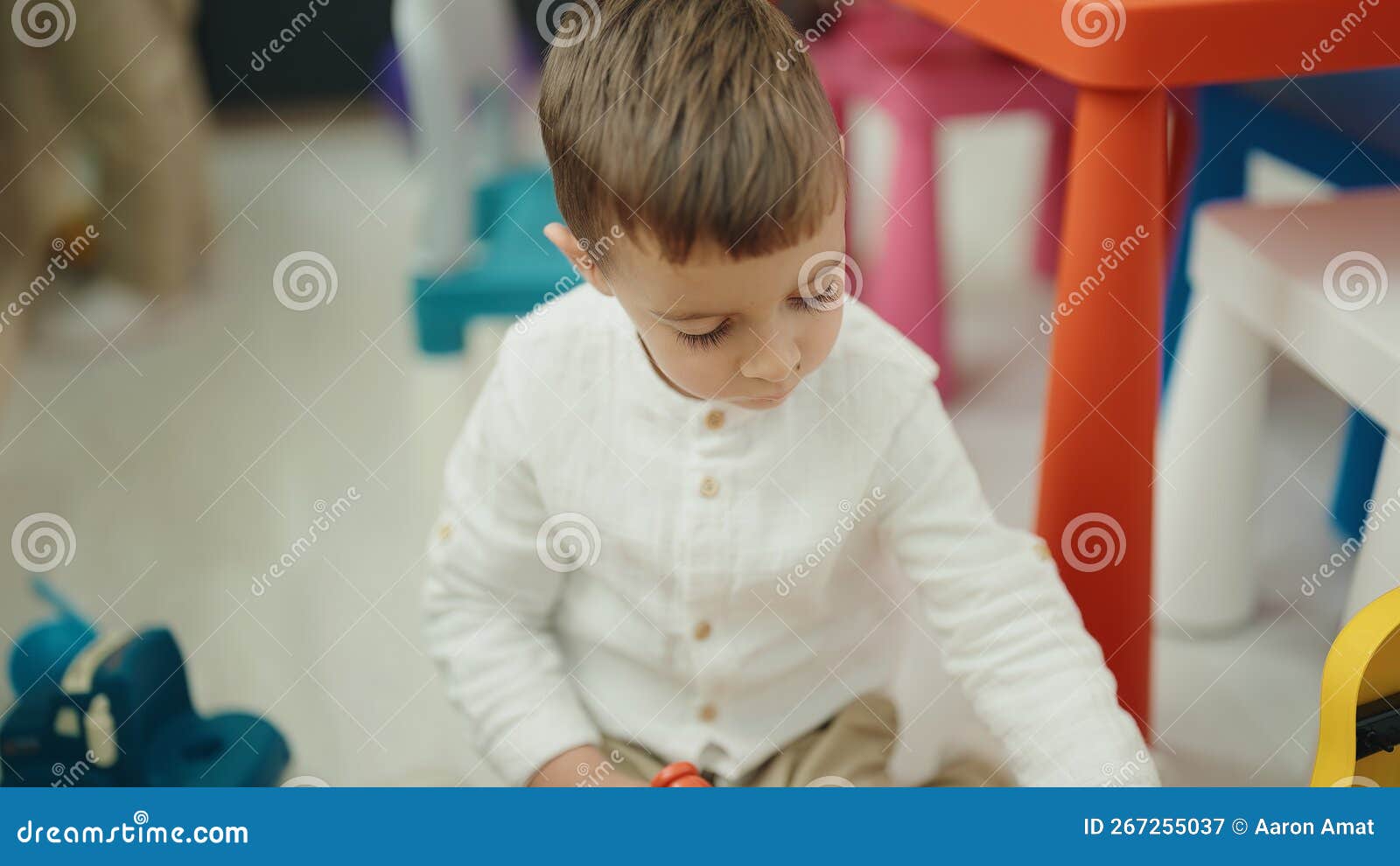 Adorable Caucasian Boy Student Sitting on Floor with Relaxed Expression ...