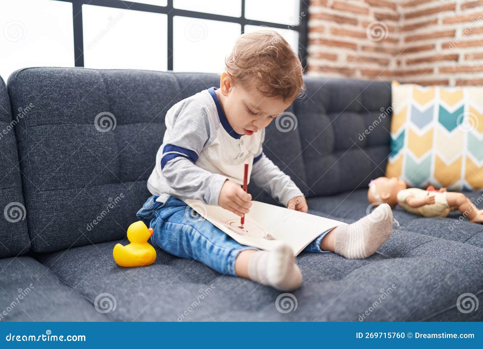 Adorable Caucasian Boy Student Sitting on Sofa Drawing on Notebook at ...