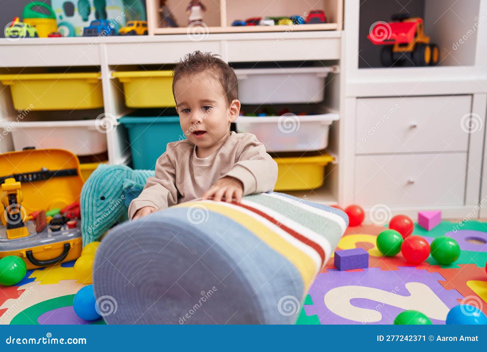 Adorable Hispanic Boy Playing with Balls Sitting on Floor at ...