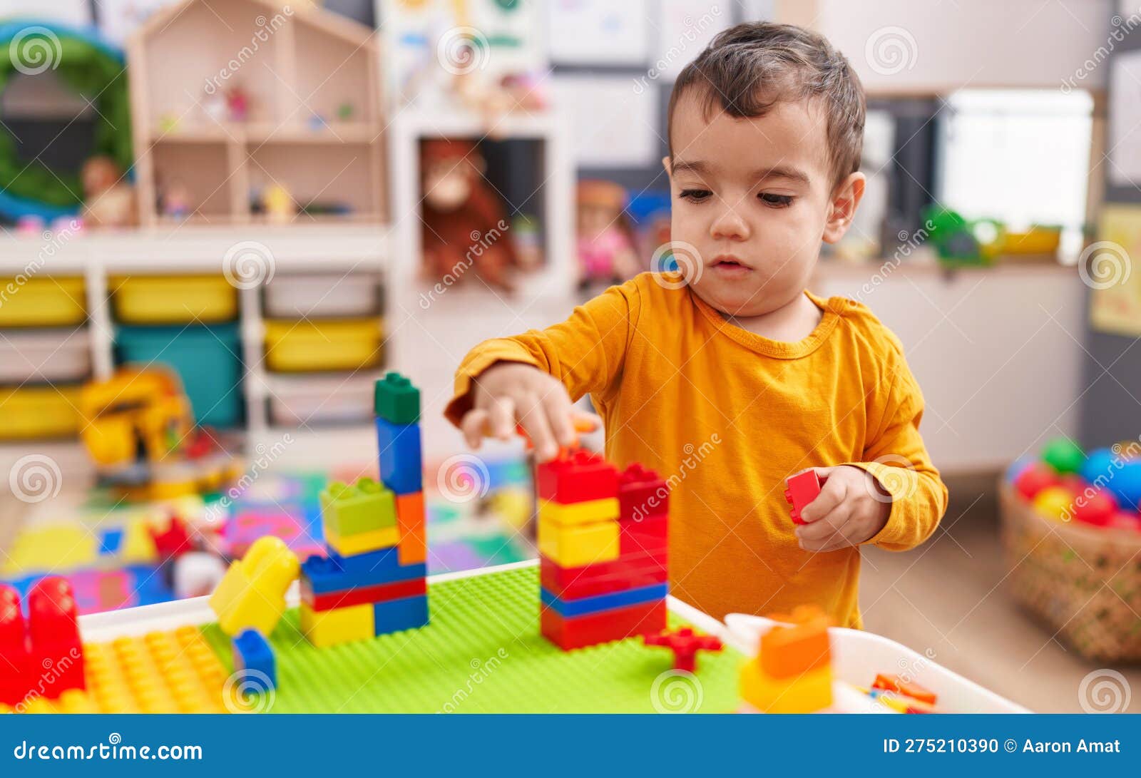Adorable Hispanic Boy Playing with Construction Blocks Standing at ...