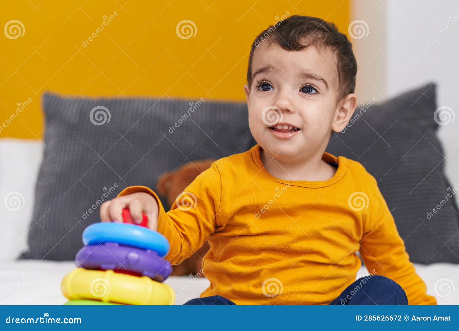 Adorable Hispanic Boy Playing with Hoops Game Sitting on Bed at Bedroom ...