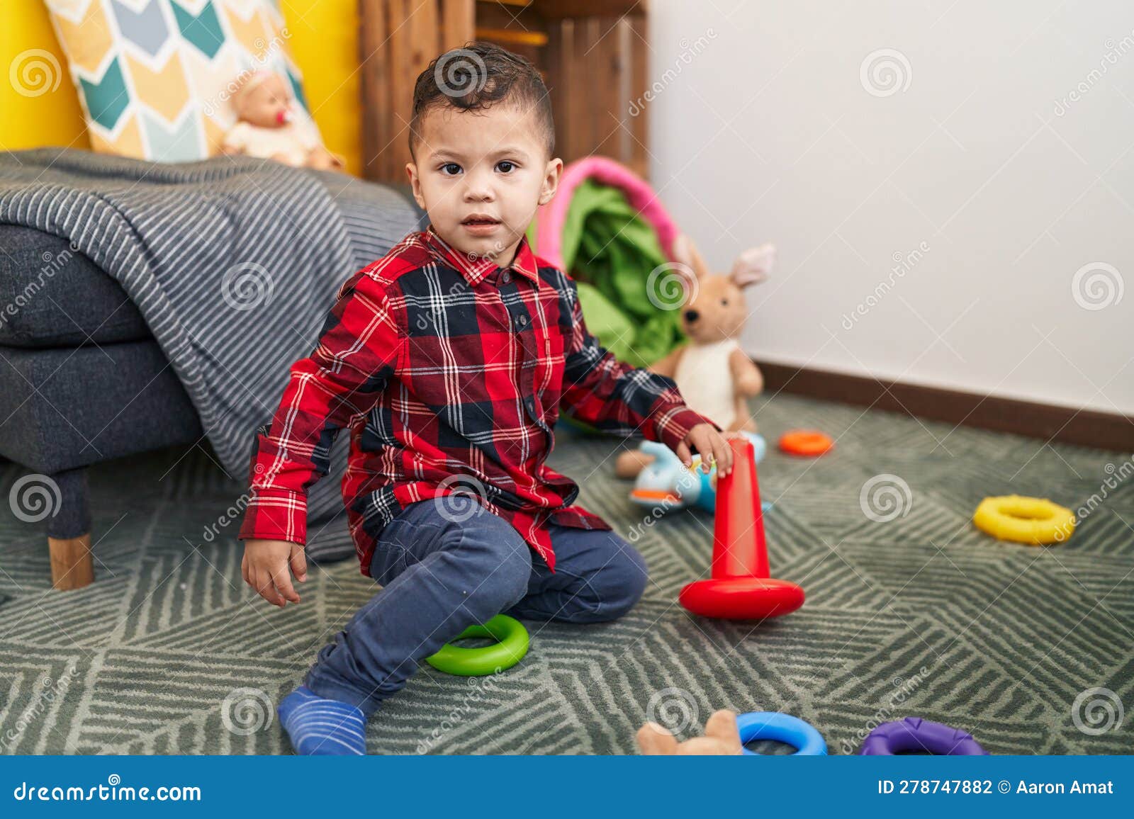 Adorable Hispanic Boy Playing with Hoops Game Sitting on Floor at Home ...