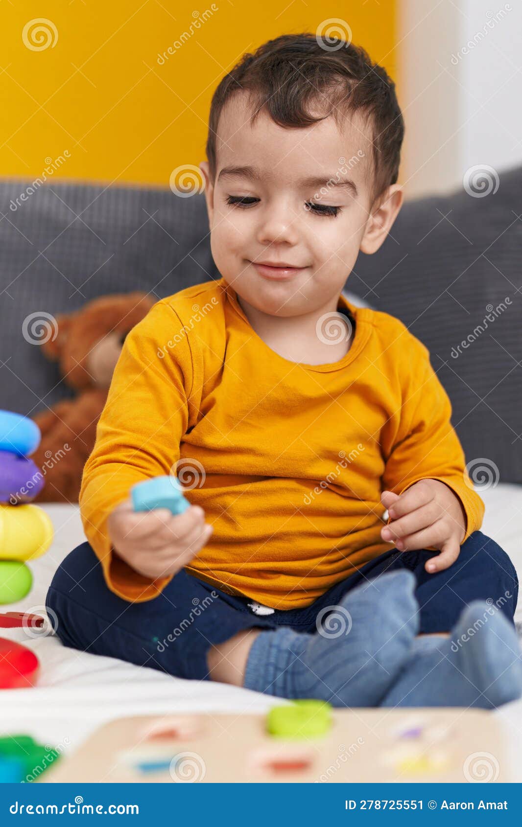 Adorable Hispanic Boy Playing with Maths Puzzle Game Sitting on Bed at ...