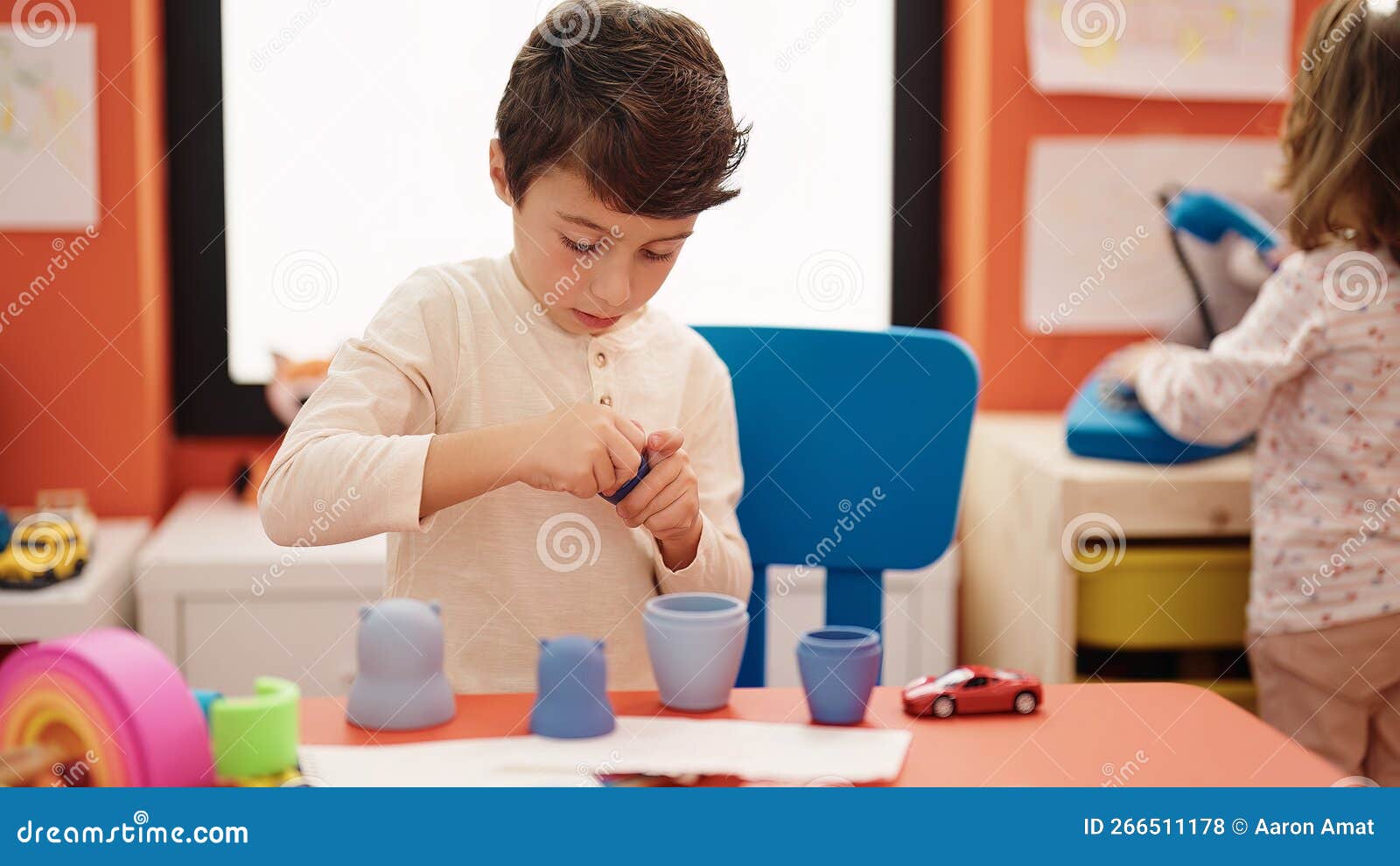 Adorable Hispanic Boy Playing with Toys Standing at Kindergarten Stock ...