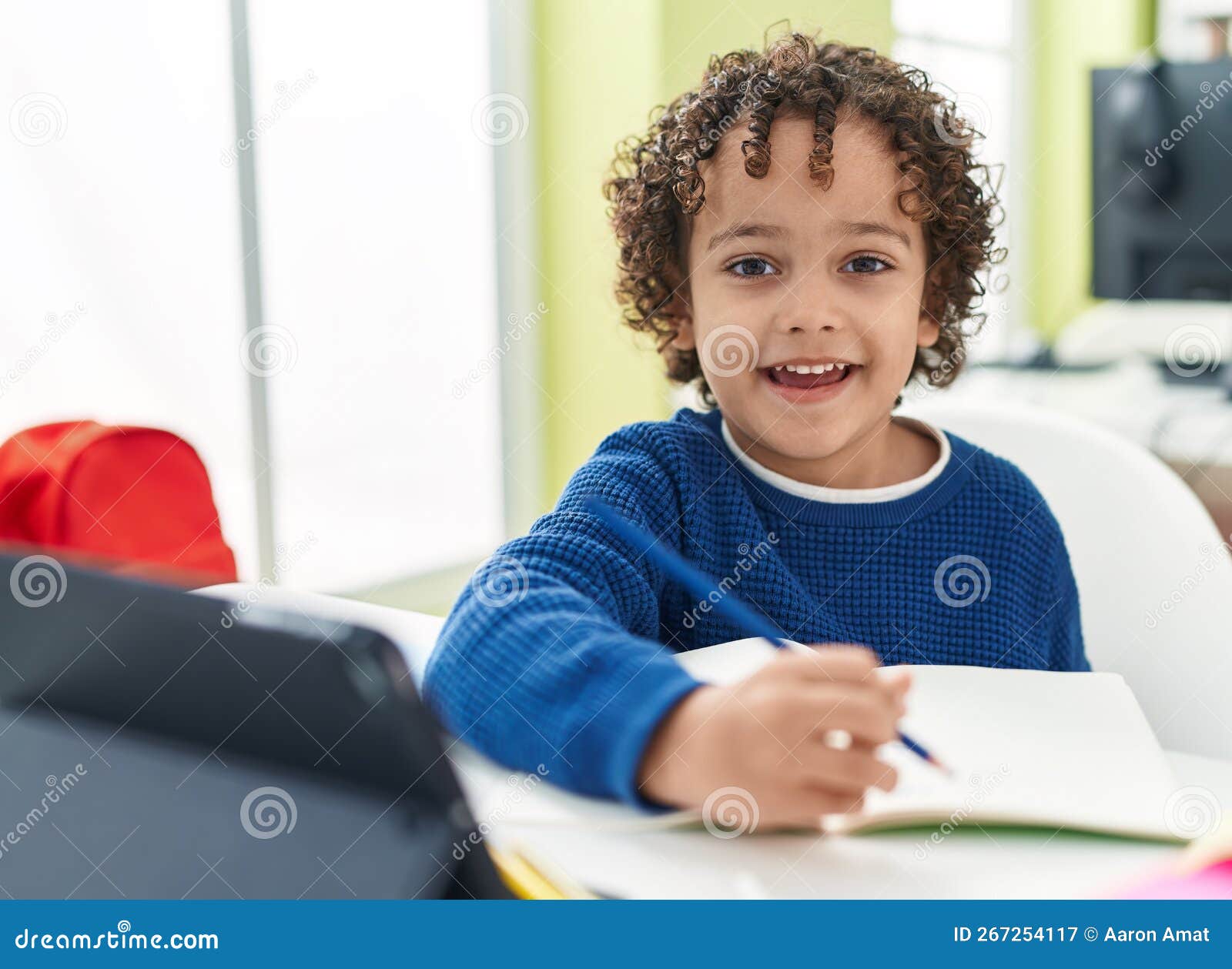 Adorable Hispanic Boy Preschool Student Sitting on Table Drawing on ...