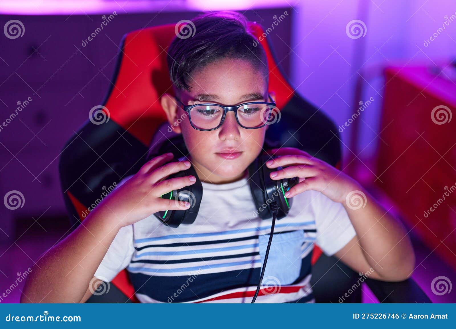 Adorable Hispanic Boy Streamer Sitting on Table with Serious Expression ...