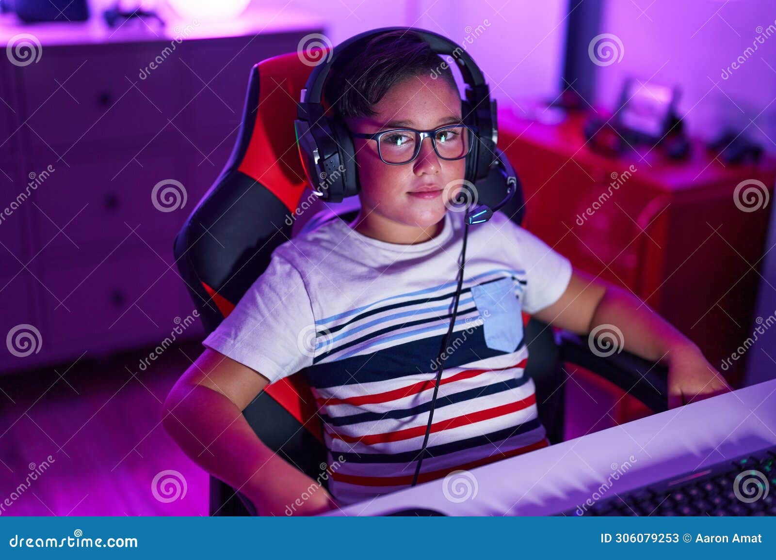 Adorable Hispanic Boy Streamer Sitting on Table with Serious Expression ...