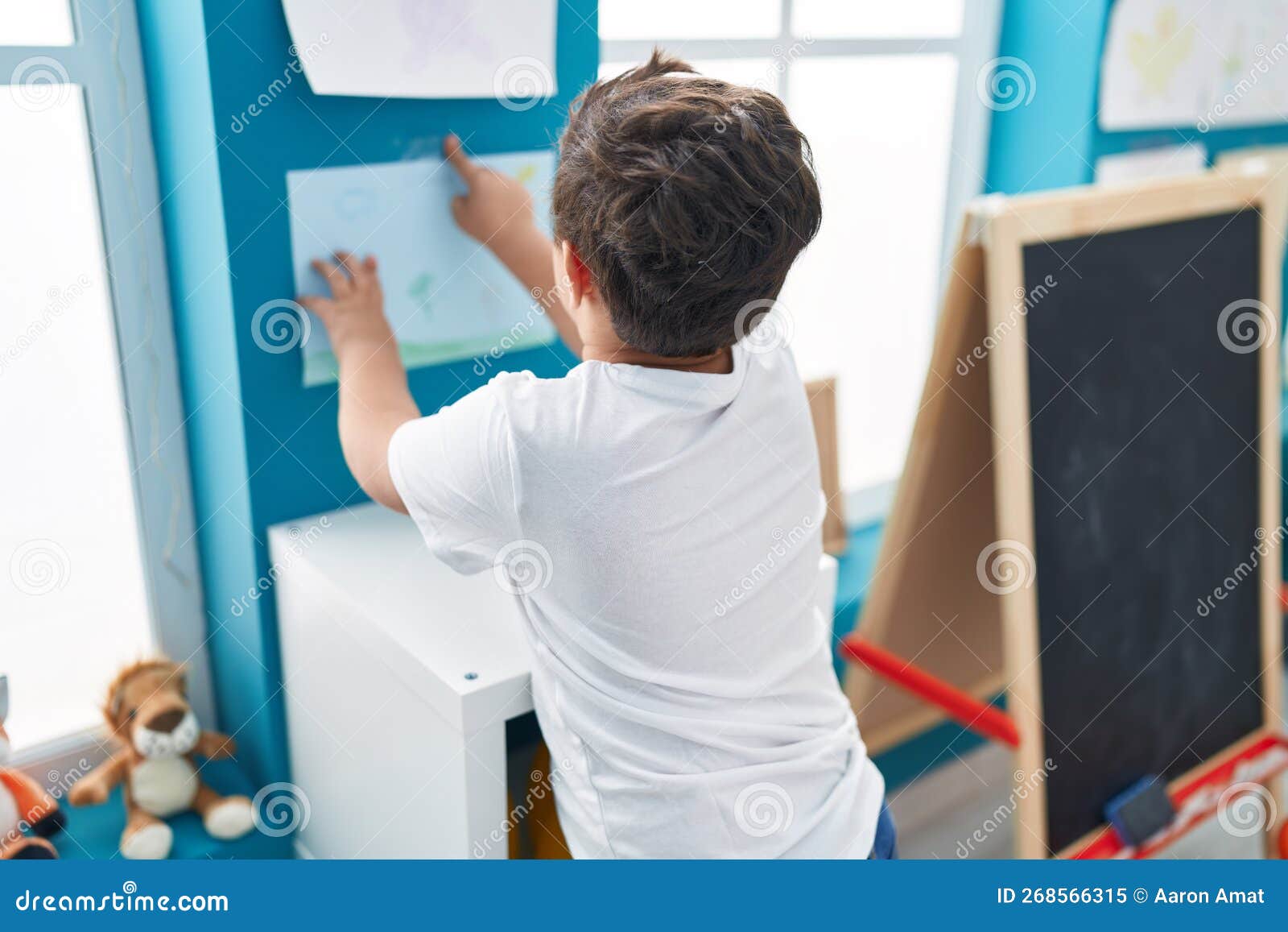 Adorable Hispanic Boy Student Hanging Draw on Wall at Kindergarten ...