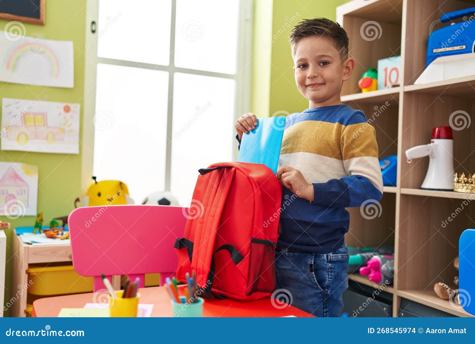 Adorable Hispanic Boy Student Holding Book of Backpack at Kindergarten ...