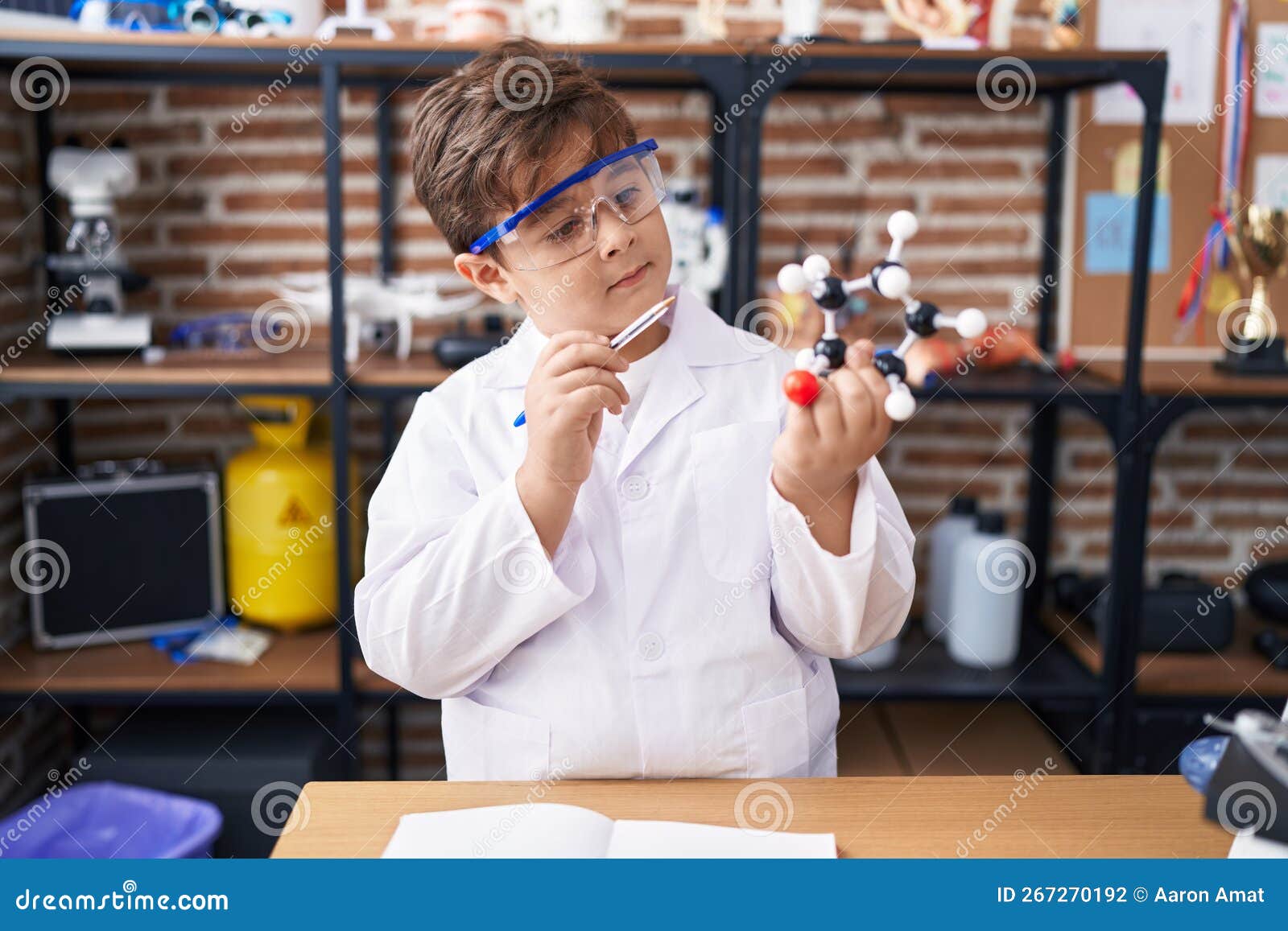 Adorable Hispanic Boy Student Looking Molecules at Laboratory Classroom ...