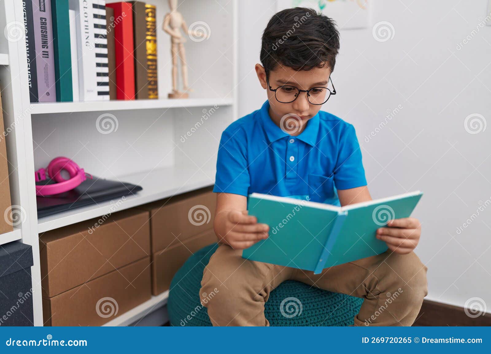 Adorable Hispanic Boy Student Reading Book at Library School Stock ...