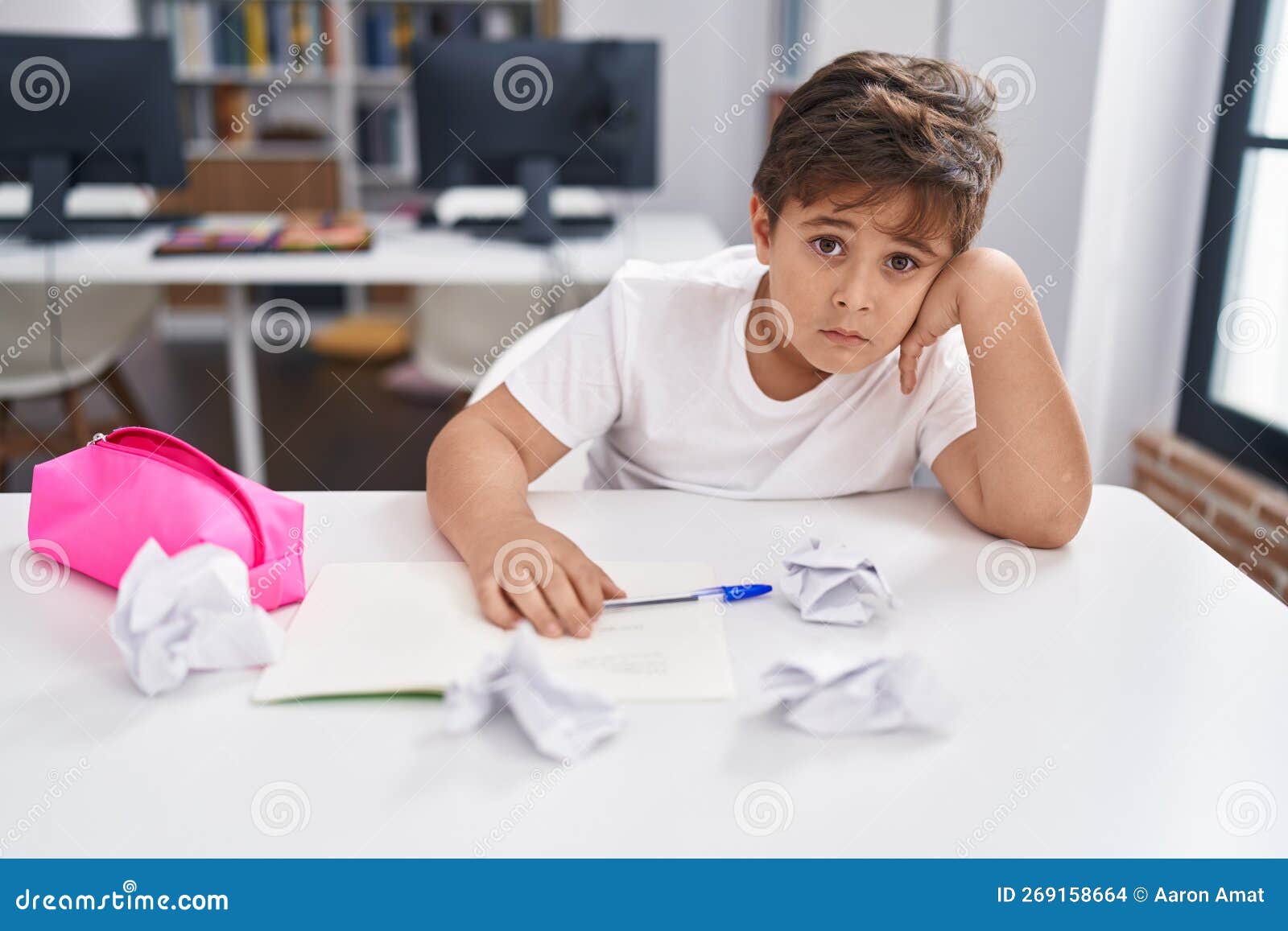 Adorable Hispanic Boy Student Sitting on Table with Worried Expression ...
