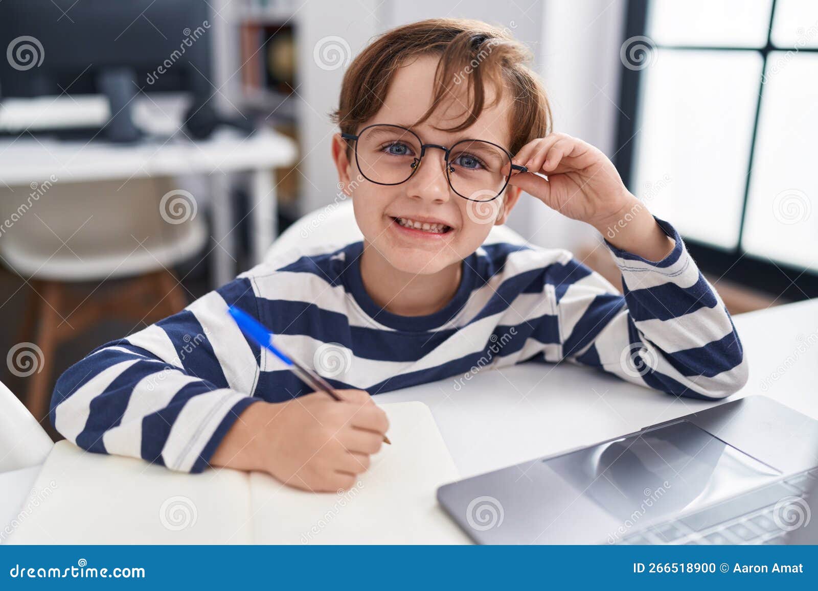 Adorable Hispanic Boy Student Using Computer Writing on Notebook at ...