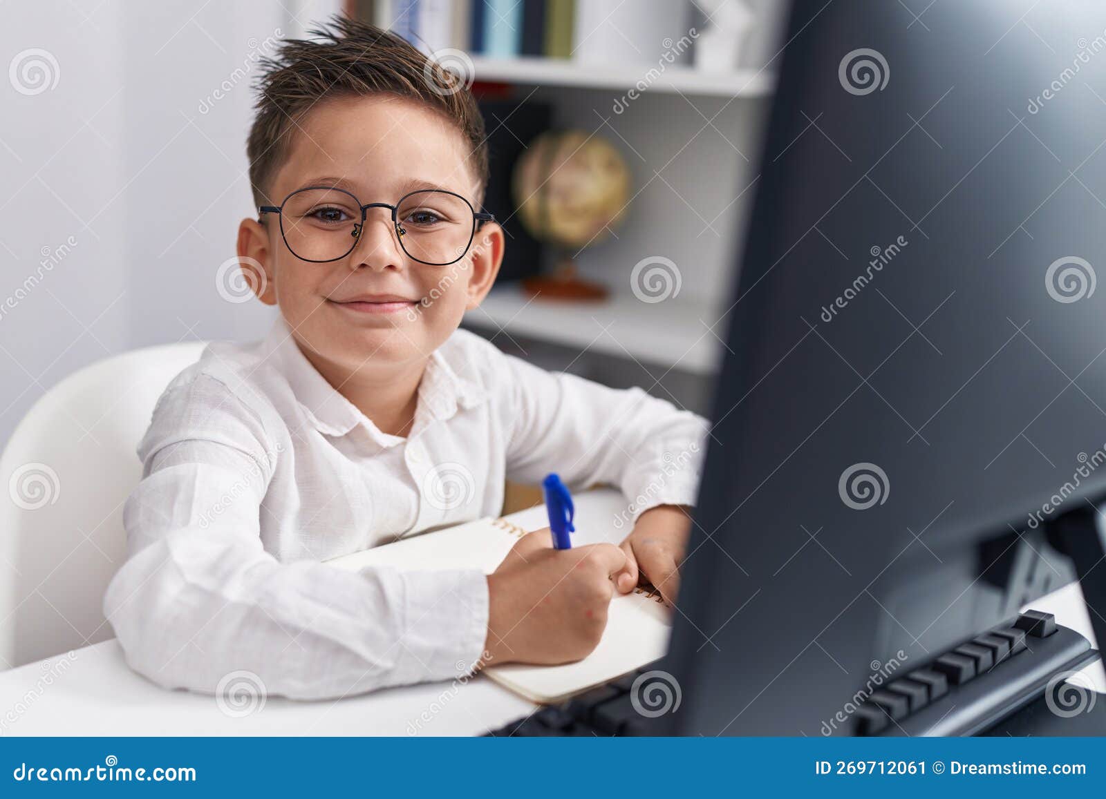 Adorable Hispanic Boy Student Using Computer Writing on Notebook at ...