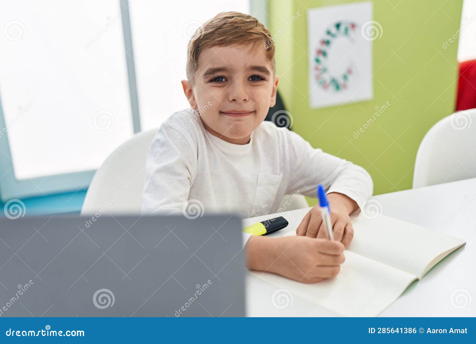 Adorable Hispanic Boy Student Using Laptop Writing Notes at Classroom ...