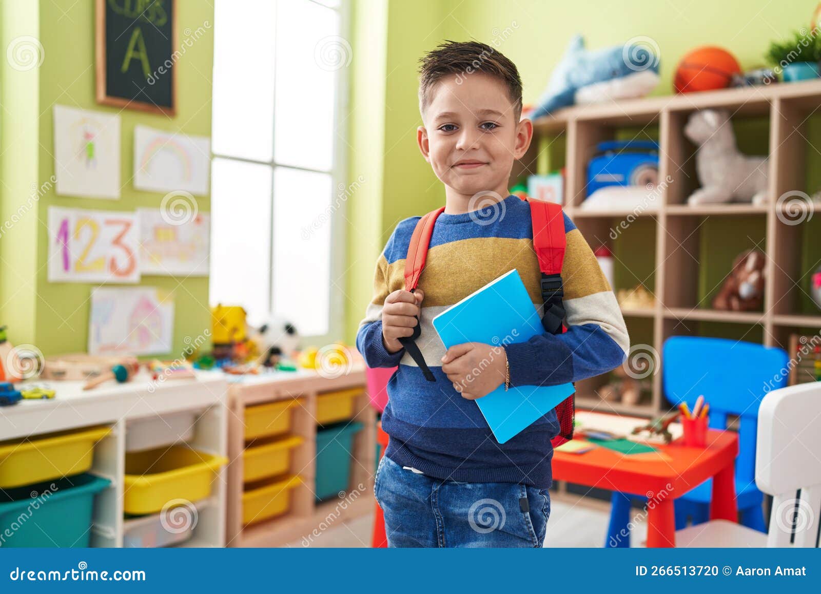 Adorable Hispanic Boy Student Wearing Backpack Holding Book at ...