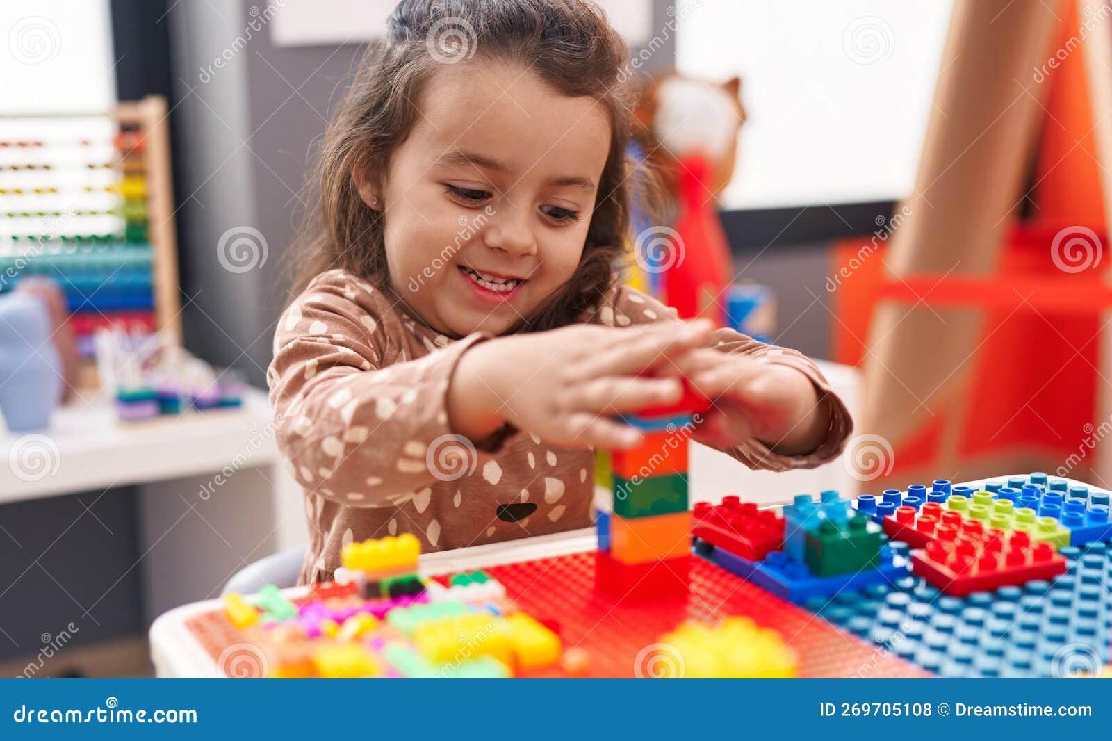 Adorable Hispanic Girl Playing with Construction Blocks Sitting on Table at Kindergarten Stock ...
