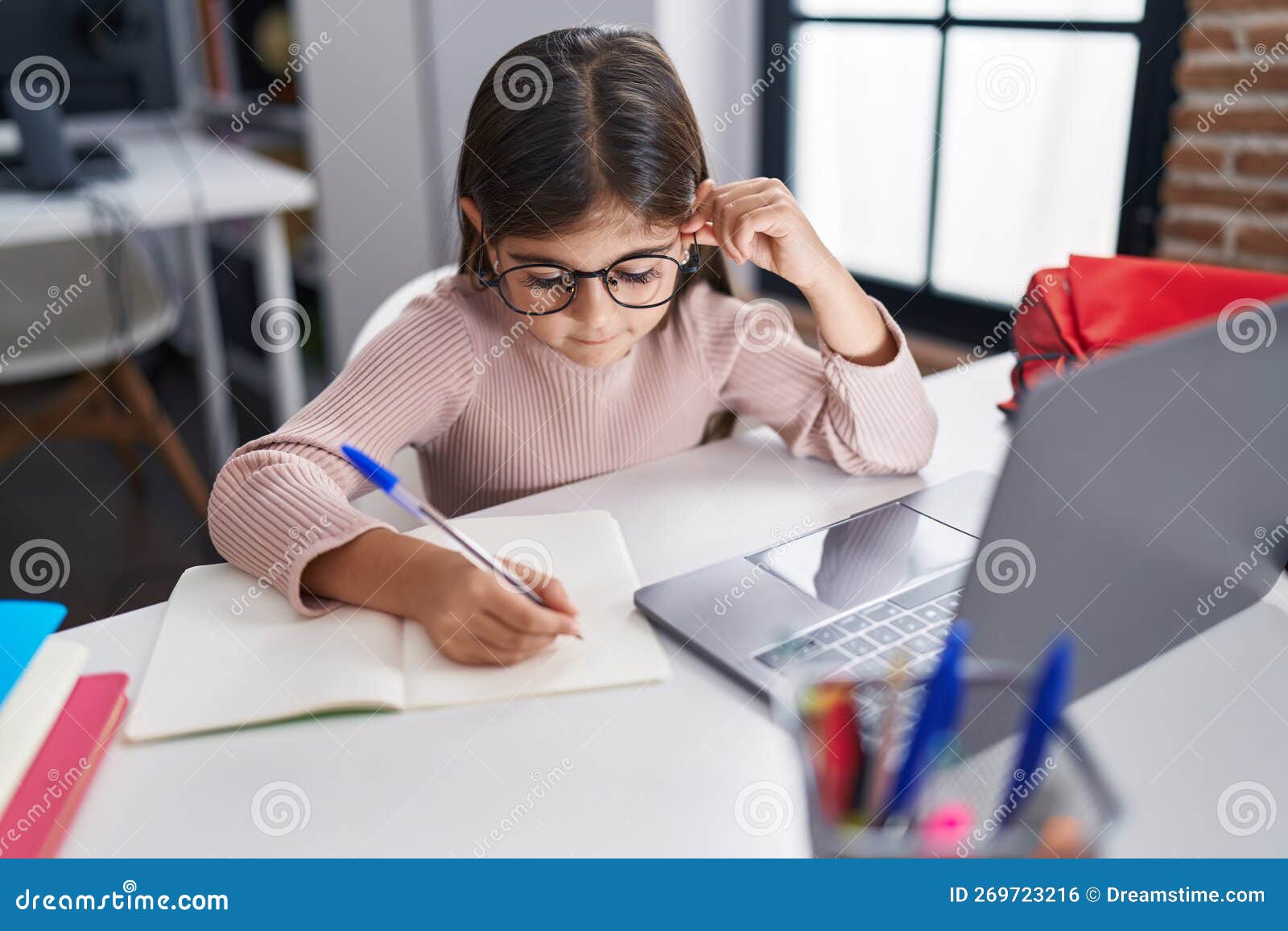 Adorable Hispanic Girl Student Using Laptop Writing on Notebook at ...