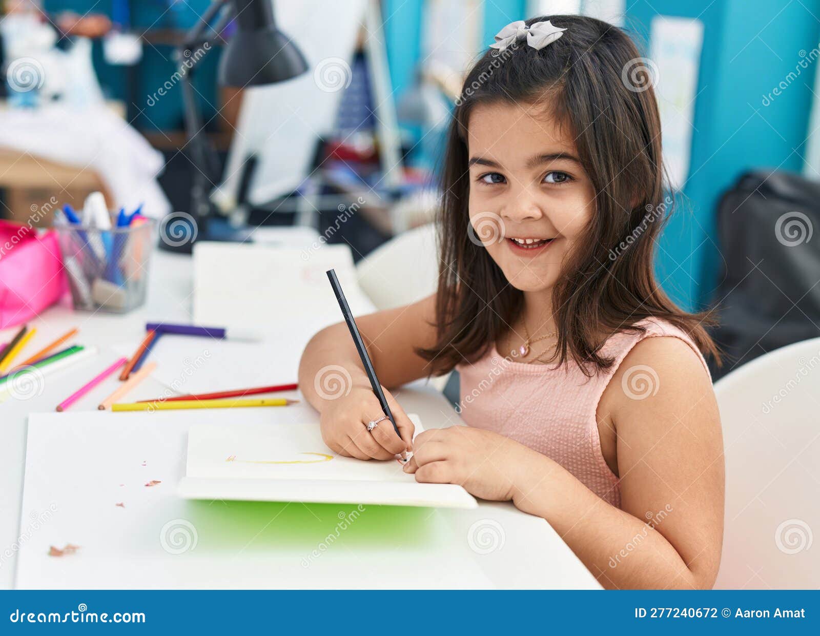 Adorable Hispanic Girl Student Writing on Notebook at Classroom Stock ...