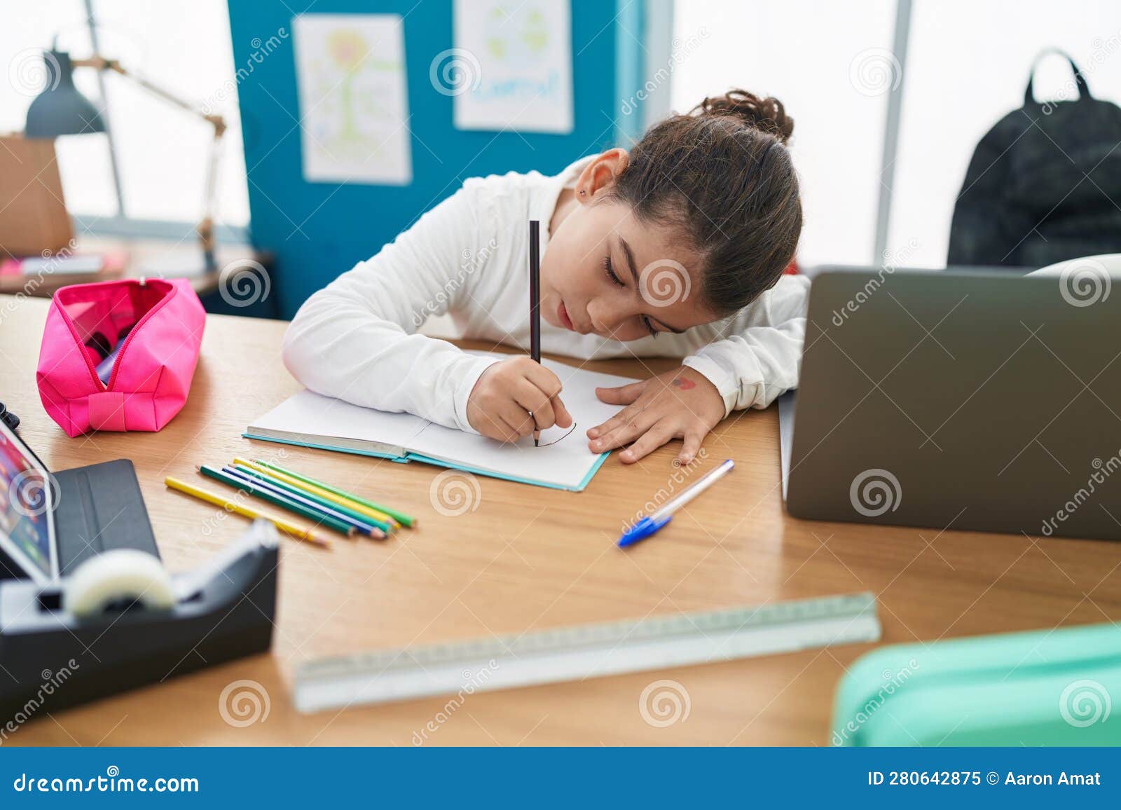 Adorable Hispanic Girl Student Writing on Notebook Using Laptop at ...