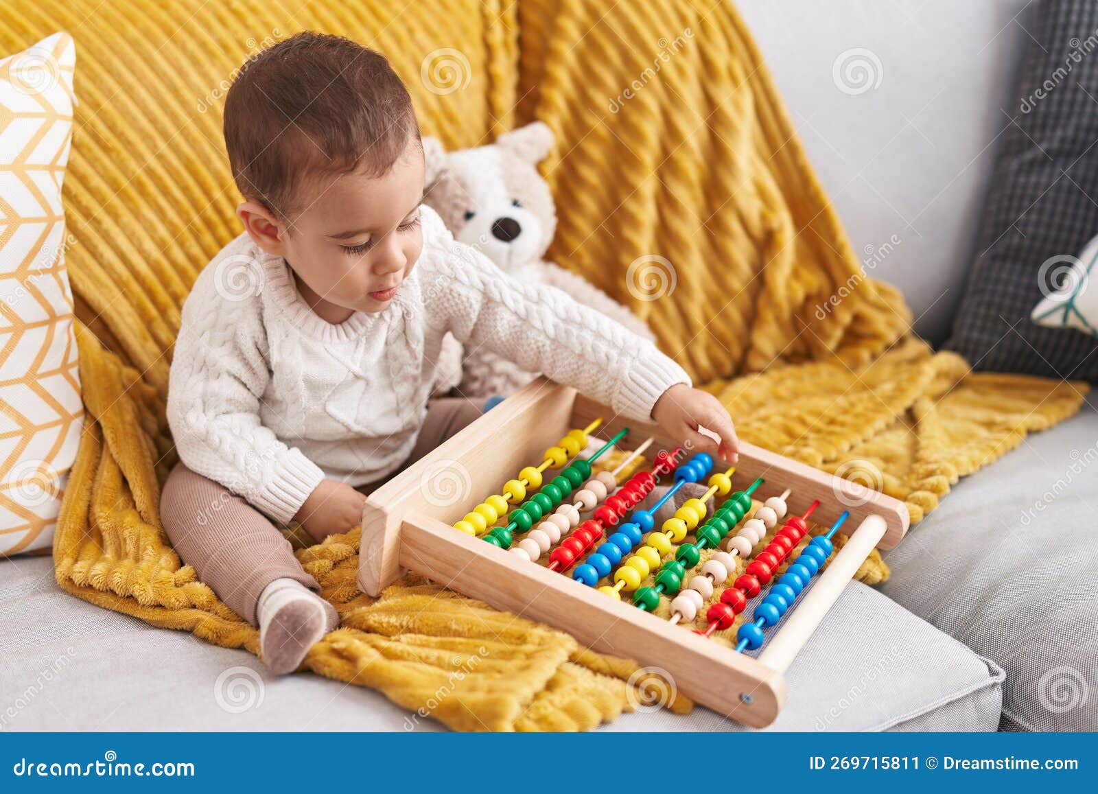 Adorable Hispanic Toddler Playing with Abacus Sitting on Sofa at Home ...