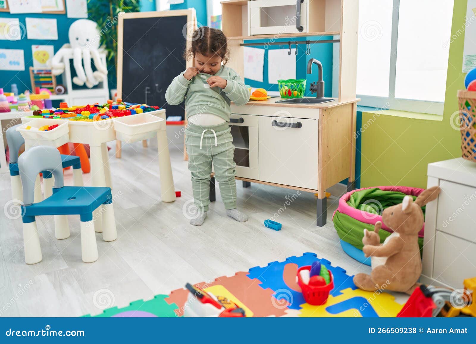 Adorable Hispanic Toddler Playing with Play Kitchen Standing at ...