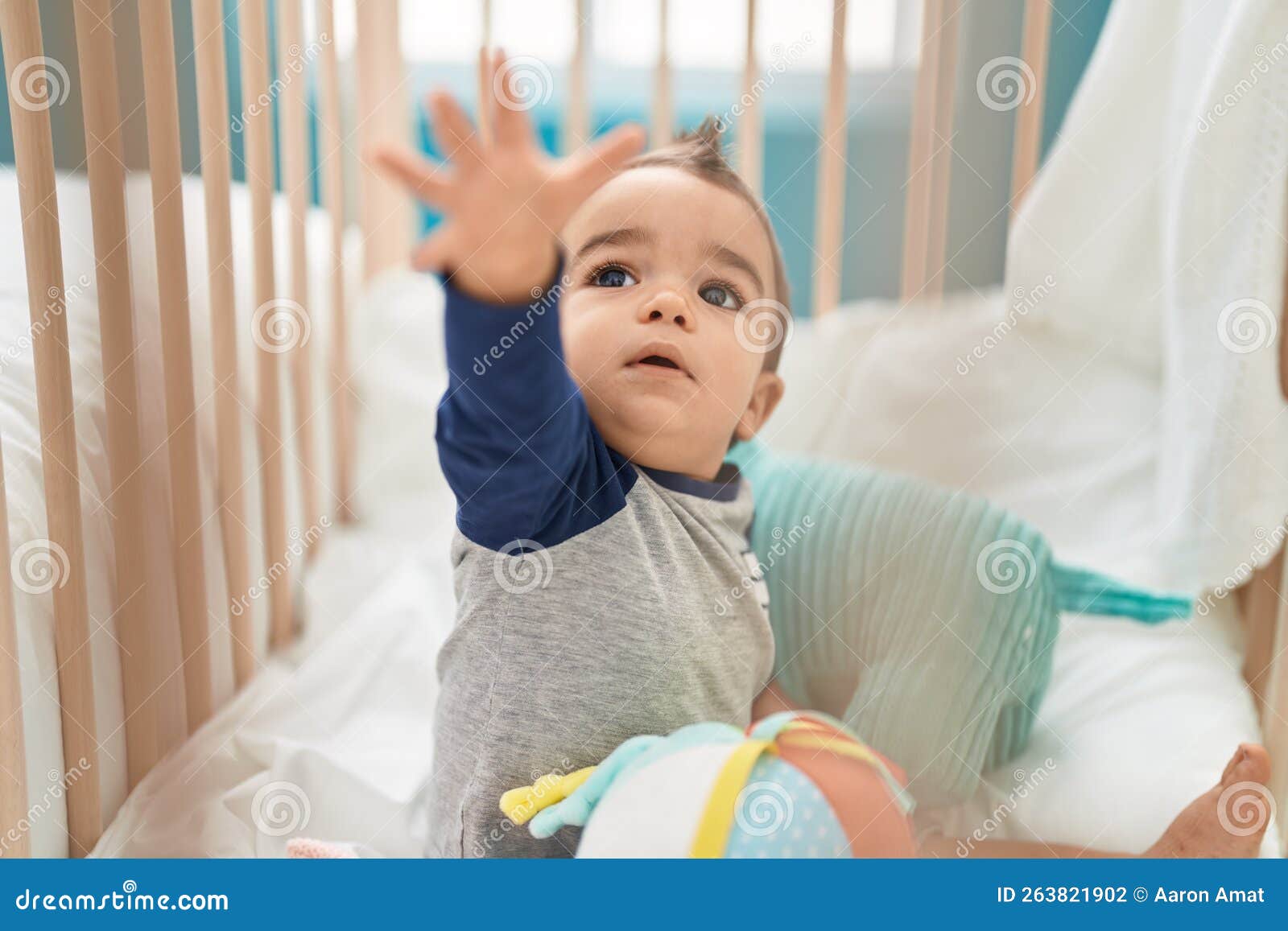 Adorable Hispanic Toddler Sitting on Cradle with Relaxed Expression at ...