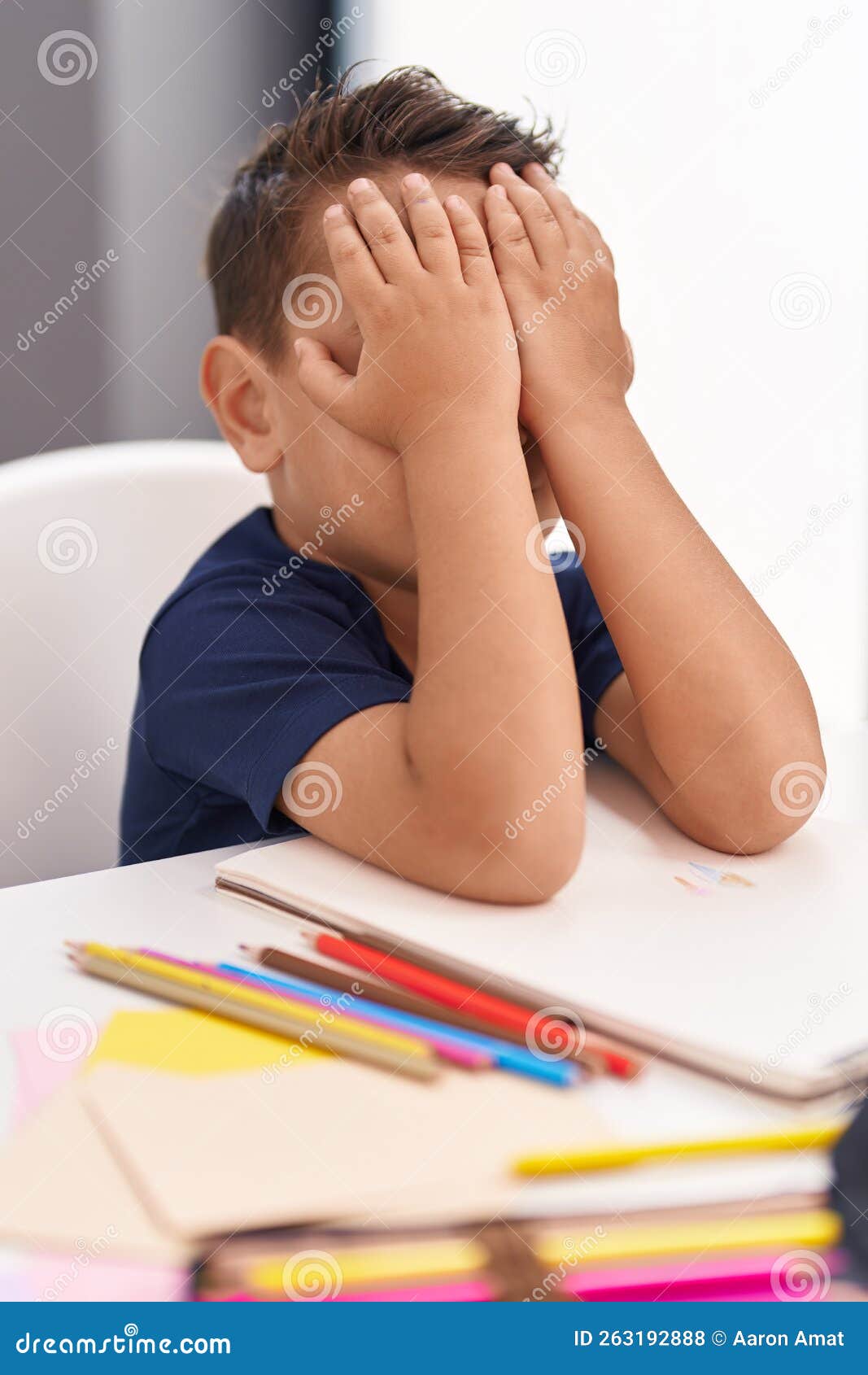 Adorable Hispanic Toddler Student Sitting on Table Crying at Classroom ...