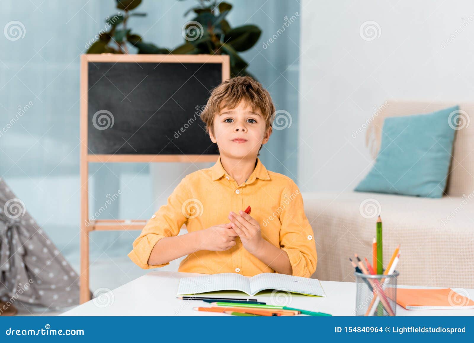 Adorable Little Boy Studying at Table and Looking Stock Photo - Image ...